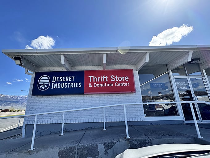 The clean white exterior and mountain backdrop prove that even thrift stores deserve a dramatic setting worthy of a Western film.