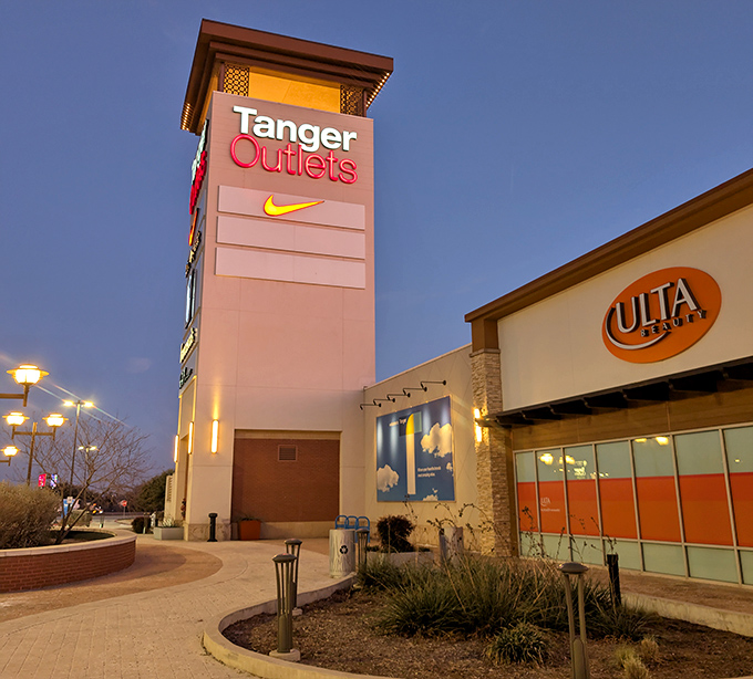 As dusk settles, Tanger's iconic tower stands like a beacon for bargain hunters, promising treasures within those illuminated walls.