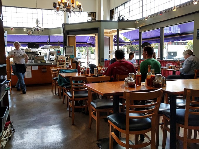 Wooden tables bathed in natural light create that perfect "third place" between home and work where conversations flow as freely as the coffee.