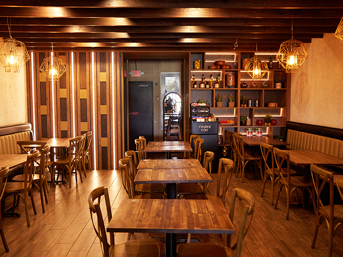 Warm wooden beams and thoughtful lighting create the perfect backdrop for the food drama about to unfold on your table.