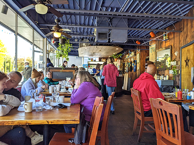 Morning magic happens inside these walls, where wooden tables fill with happy diners and hanging plants add a touch of greenery to the industrial-chic ceiling.