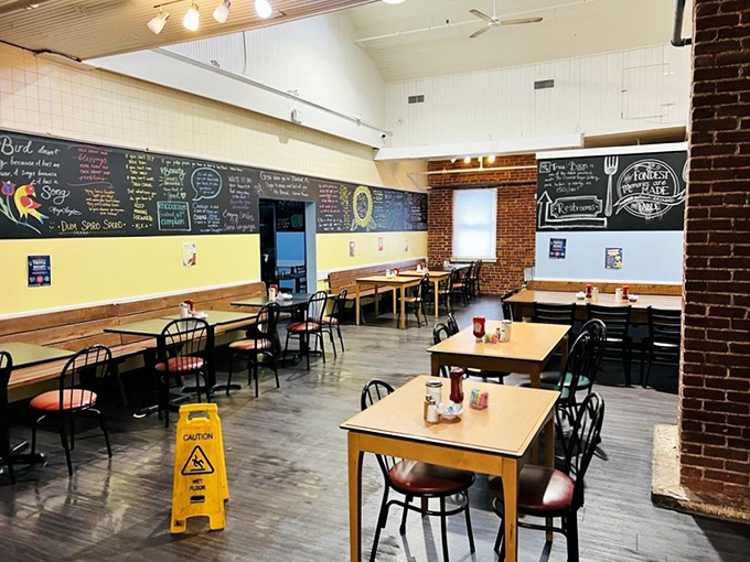 Exposed brick meets cheerful yellow walls in this dining space where chalkboard menus showcase daily specials with artistic flair &ndash; comfort food with a side of creativity.