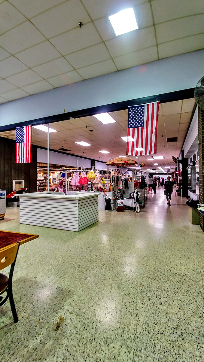 American flags hang proudly overhead as shoppers navigate the wide corridors, creating a patriotic canopy for the treasure hunt below.