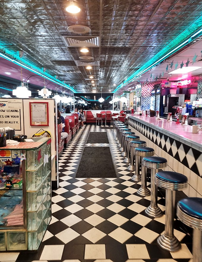 Step inside and the checkerboard floor leads you past chrome stools to red vinyl booths where calories don't count and neon casts everything in that perfect "American Graffiti" glow.