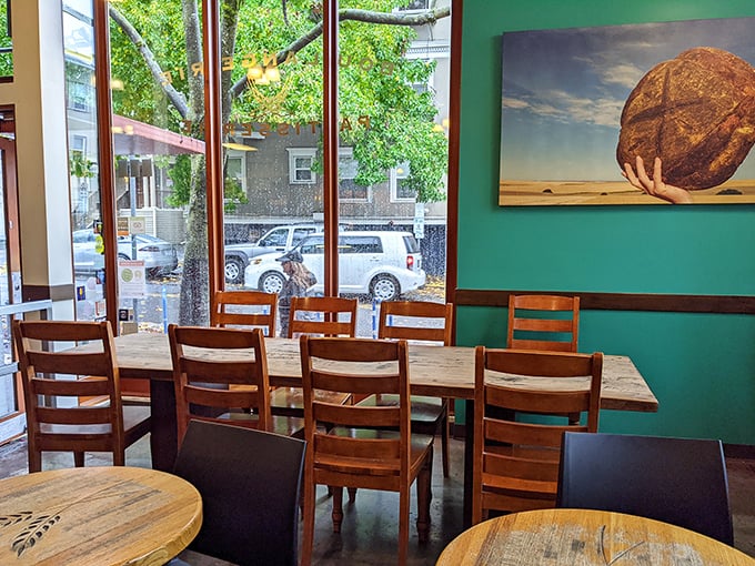 Wooden tables bathed in natural light create the perfect stage for your impending carbohydrate ballet. That bread photo watches over diners like a delicious guardian angel.