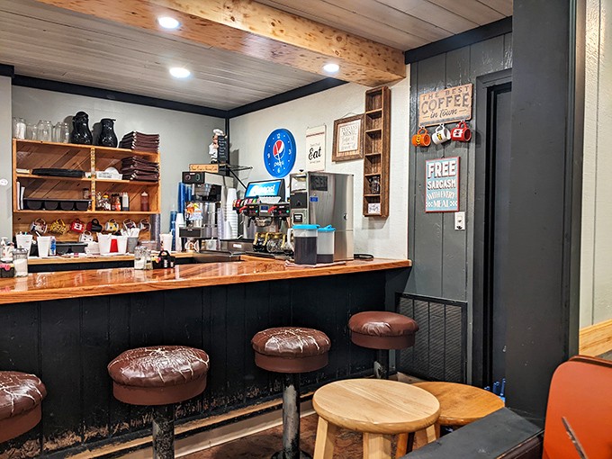 Counter seating with vintage leather stools where regulars exchange local gossip while coffee flows freely. The breakfast theater is half the experience.