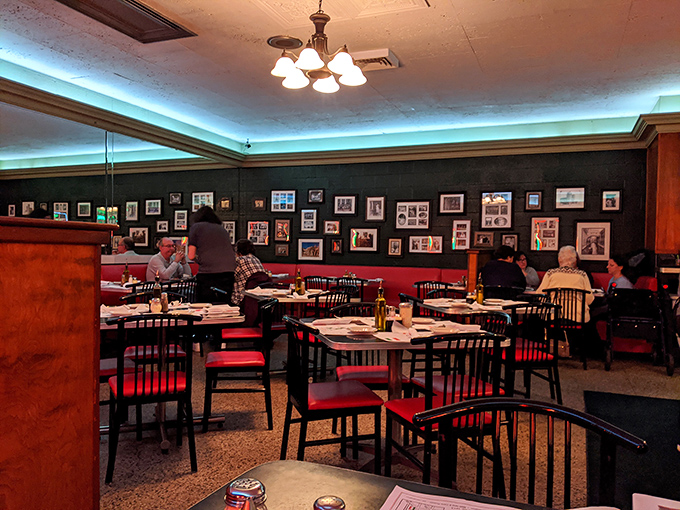 Family photos line the walls while the soft blue lighting creates an atmosphere that's part time capsule, part cozy Italian home.