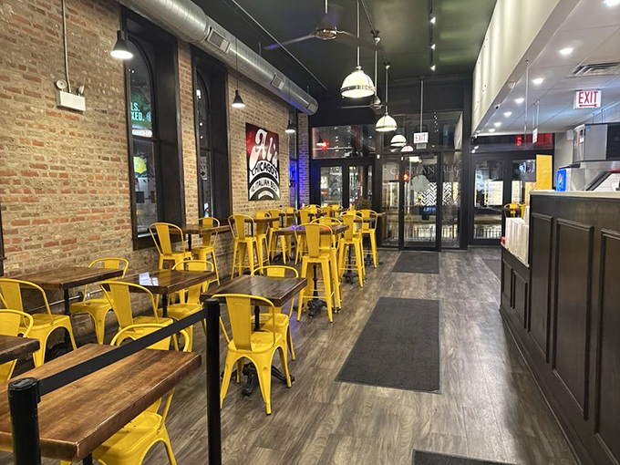 Bright yellow chairs against exposed brick create that perfect balance of modern comfort and old-school Chicago charm inside Al's.
