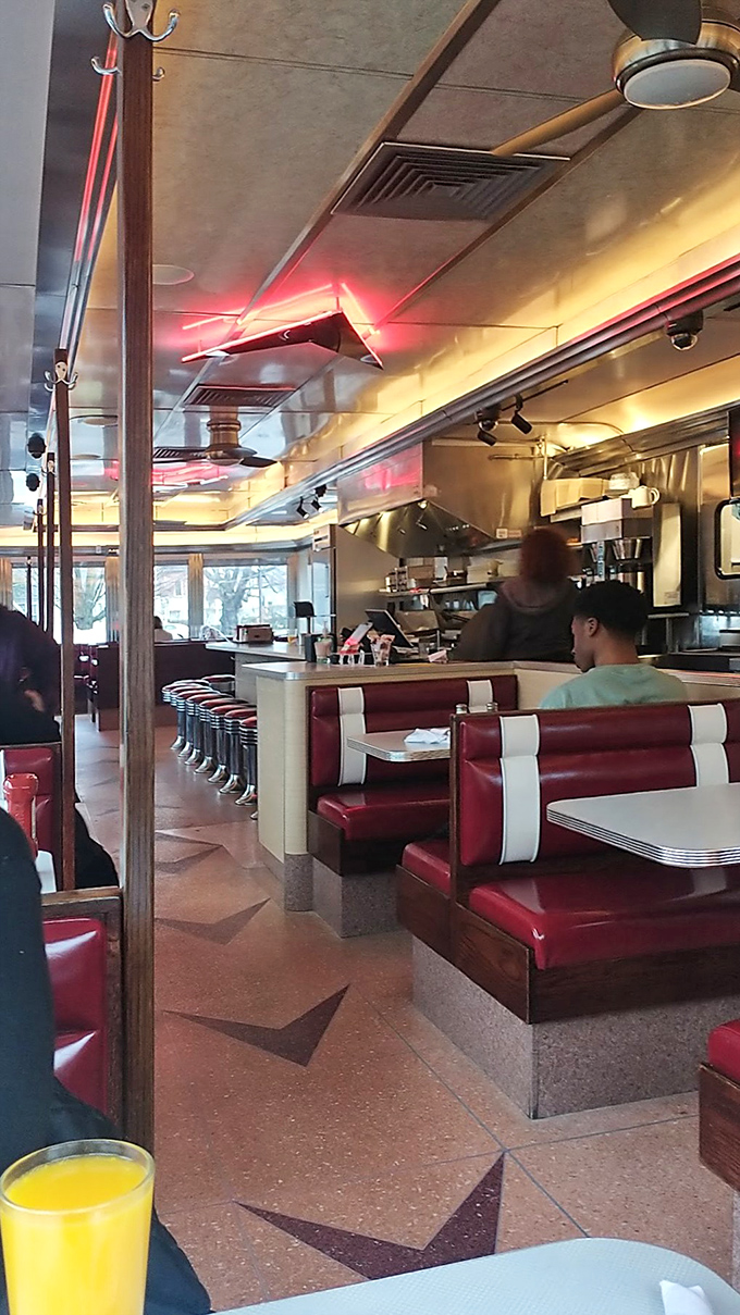 Red and white booths line the interior like candy canes of comfort, where conversations flow as freely as the coffee.