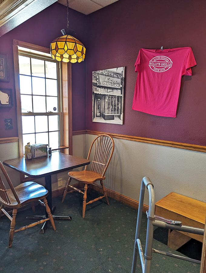 Purple walls and Tiffany-style lamps create a cozy time capsule where wooden chairs have witnessed decades of butter-induced happiness.