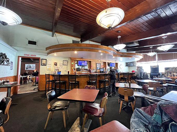 Step inside where wood paneling and pendant lights create the perfect steakhouse time capsule atmosphere.