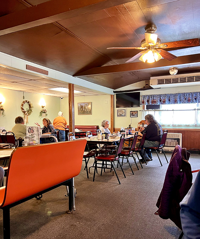 Inside, wood-paneled walls and ceiling fans create that perfect small-town diner atmosphere where conversations flow as freely as the coffee.