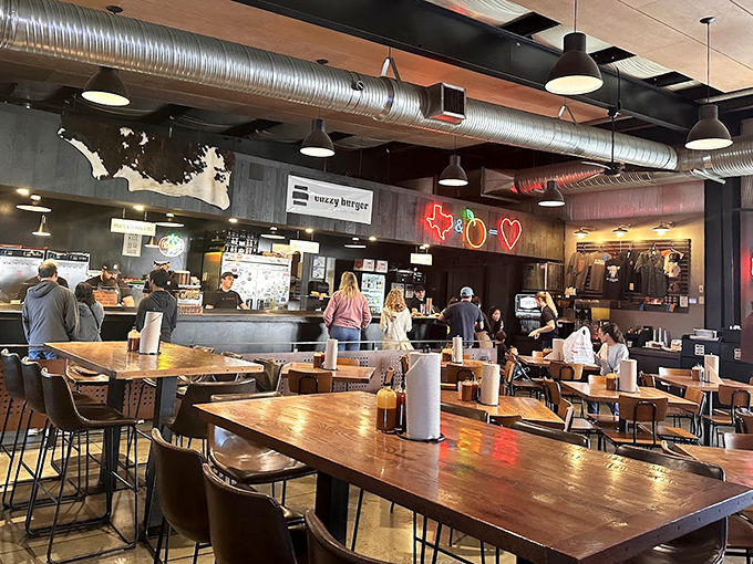 Industrial chic meets barbecue warmth inside ZZQ. That neon Texas outline isn't just decoration&mdash;it's a promise of authenticity that your taste buds will soon confirm.