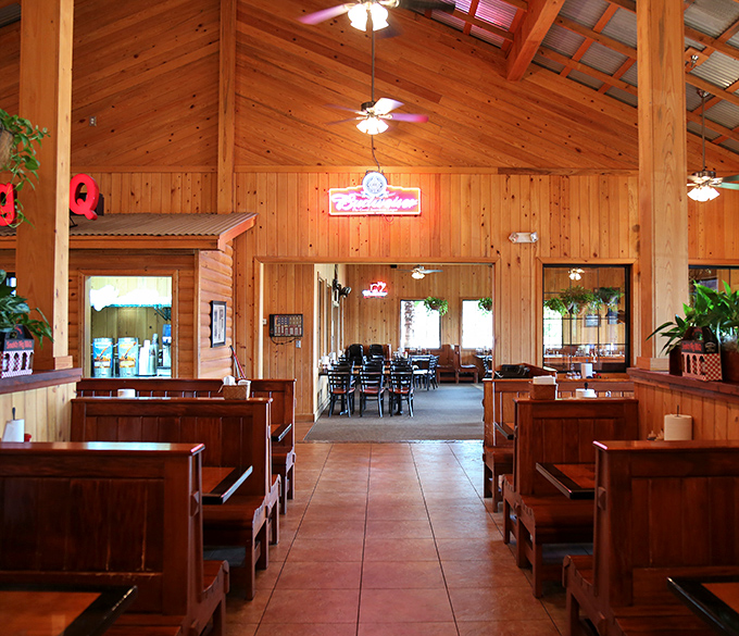 Cathedral-like wooden beams soar overhead while booth seating keeps conversations intimate. This isn't architecture &ndash; it's BBQ atmosphere engineering.