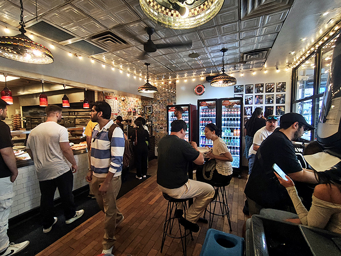 Inside Joe's, the pressed tin ceiling and string lights create that perfect "I've found the real deal" atmosphere where pizza magic happens daily.