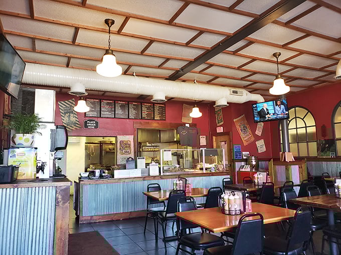 Red walls, wooden beams, and pendant lights create that perfect "come as you are, stay for seconds" atmosphere that every great BBQ joint needs.