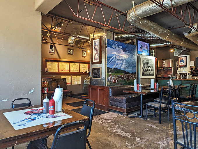 Industrial meets homey in this dining room where exposed ductwork watches over tables ready for serious barbecue business and walls tell Oklahoma stories.