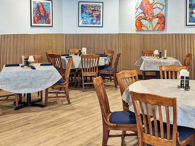 Simple wooden chairs and vibrant lobster artwork create an unpretentious dining room where the food, not the decor, rightfully takes center stage.