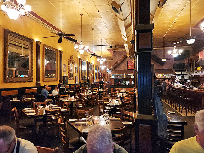 Amber lighting bathes wooden tables in a warm glow, creating that perfect steakhouse ambiance where memories are made and steaks are savored.