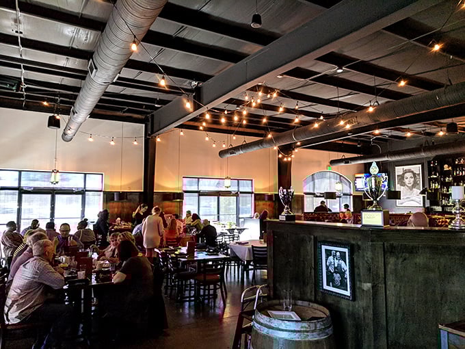 Industrial chic meets cozy comfort. String lights dance across exposed ductwork while diners engage in that universal ritual: the silent reverence of the first perfect bite.