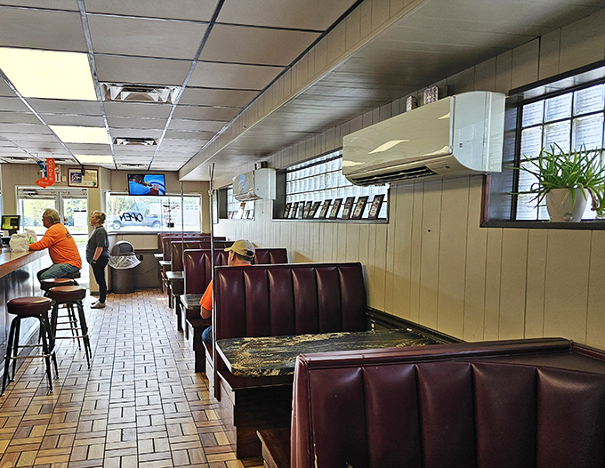 Inside, burgundy booths and wood paneling create a time capsule where conversations flow as smoothly as the milkshakes.