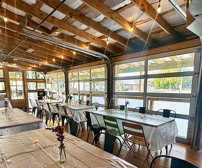 Exposed beams, garage doors that open wide, and natural light flooding in make this the ultimate relaxed dining setup.