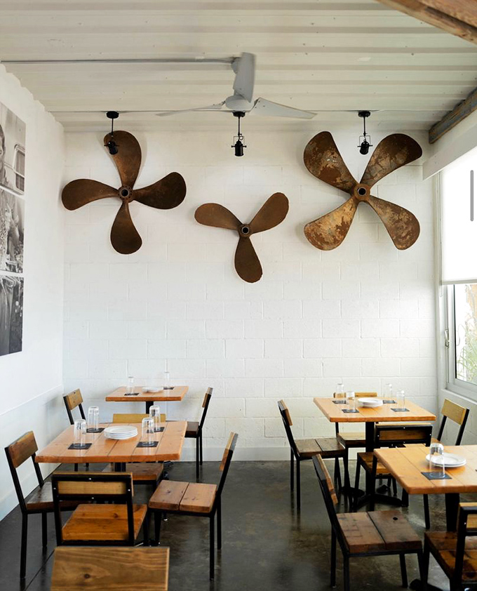Boat propellers transformed into industrial art pieces. These weathered nautical relics tell silent stories of ocean journeys while you enjoy fresh catches below.