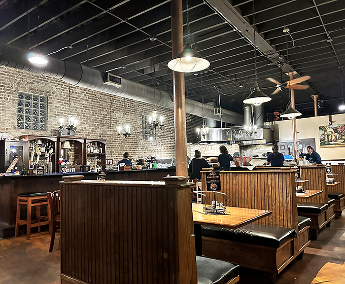 Exposed brick meets industrial chic in a space where the real star is that glowing oven in the back.
