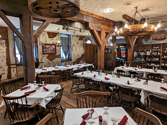 Massive wooden beams frame white-clothed tables, creating a dining room where history and hunger meet in perfect harmony.