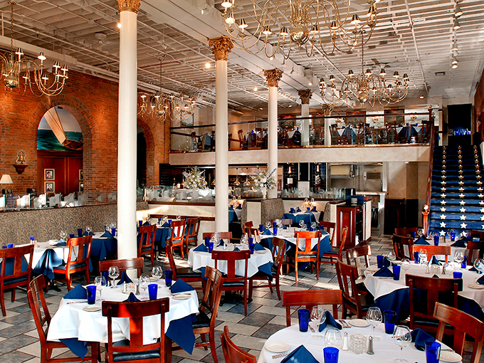 Two-story elegance with exposed brick and white columns creates the perfect backdrop for seafood indulgence. Those chandeliers have witnessed countless "oohs" over first oyster bites.