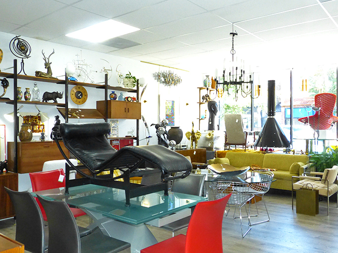 Step inside and time travel begins. This showroom vignette features the holy trinity of vintage shopping: iconic lounge chair, glass table, and conversation-starting lighting.