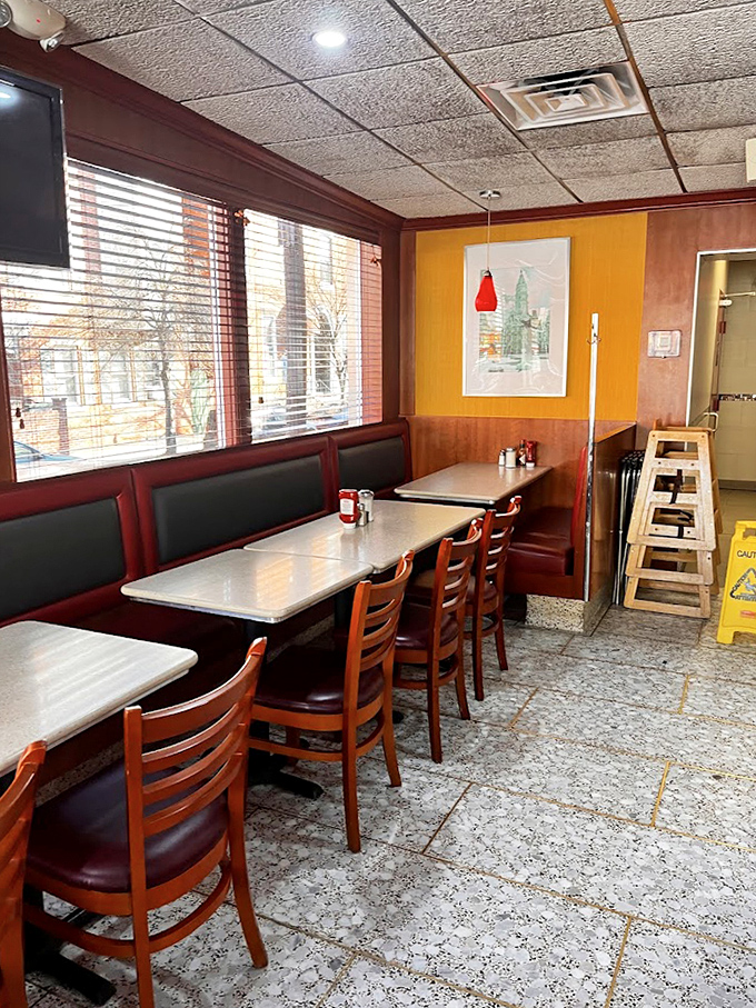 Warm wood paneling and cherry-red booths create that timeless diner atmosphere where conversations flow as freely as the coffee.