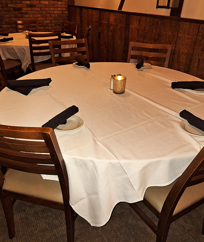White tablecloths, wooden paneling, and candlelight create that perfect sweet spot between "special occasion fancy" and "comfortable enough to actually enjoy yourself."