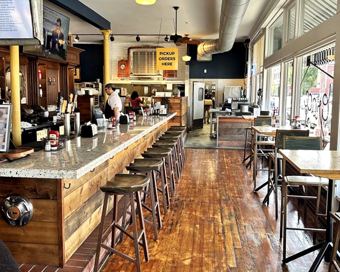 The warm wooden bar with its rustic stools invites you to pull up a seat and stay awhile. Edison bulbs overhead cast a glow that says "good food happens here."