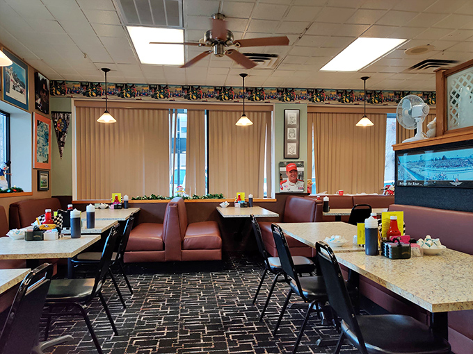 Sunshine streams through vertical blinds, illuminating burgundy booths that have cradled generations of Indianapolis diners seeking pancake perfection and tenderloin treasures.