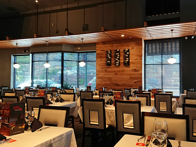 White tablecloths and elegant place settings await, while warm wood accents create that perfect balance of "fancy enough for a celebration, comfortable enough to loosen your belt."