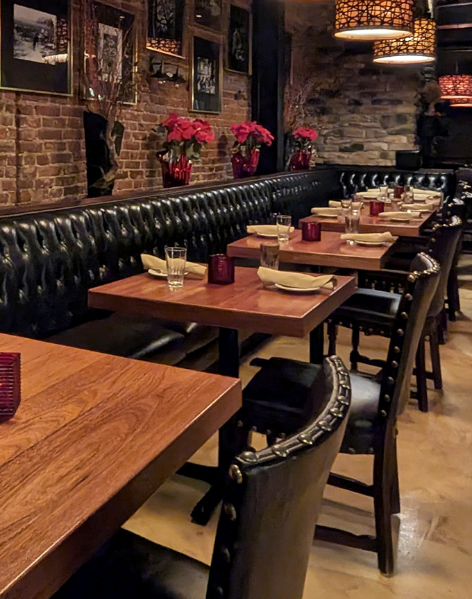 Leather banquettes and warm wood tables create that perfect "I'm-treating-myself-tonight" atmosphere, with fresh flowers adding pops of color against exposed brick.