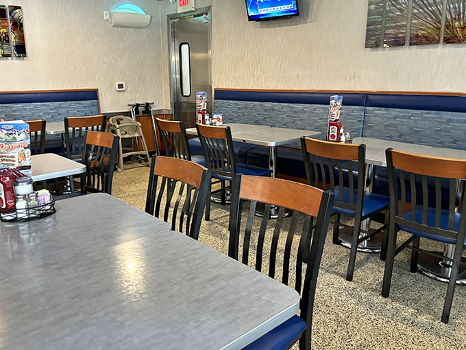 Inside, that perfect diner atmosphere awaits &ndash; wooden chairs, blue upholstery, and tables arranged just right for both privacy and people-watching.