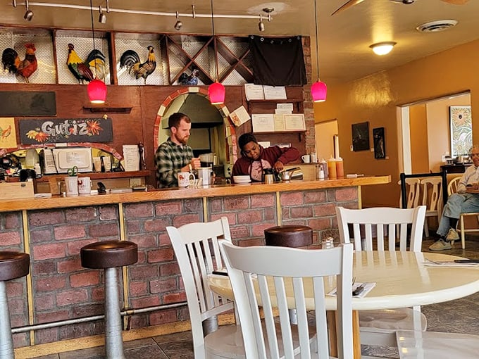 Inside, colorful rooster art watches over diners while pink pendant lights cast a warm glow. The counter service setup says, "We're casual, but our food is serious business."