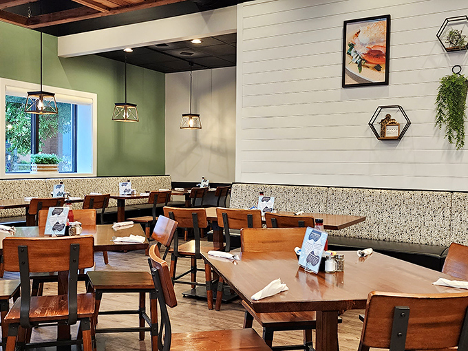 Modern meets cozy in this thoughtfully designed space where wooden tables and green walls create the perfect backdrop for breakfast bliss.