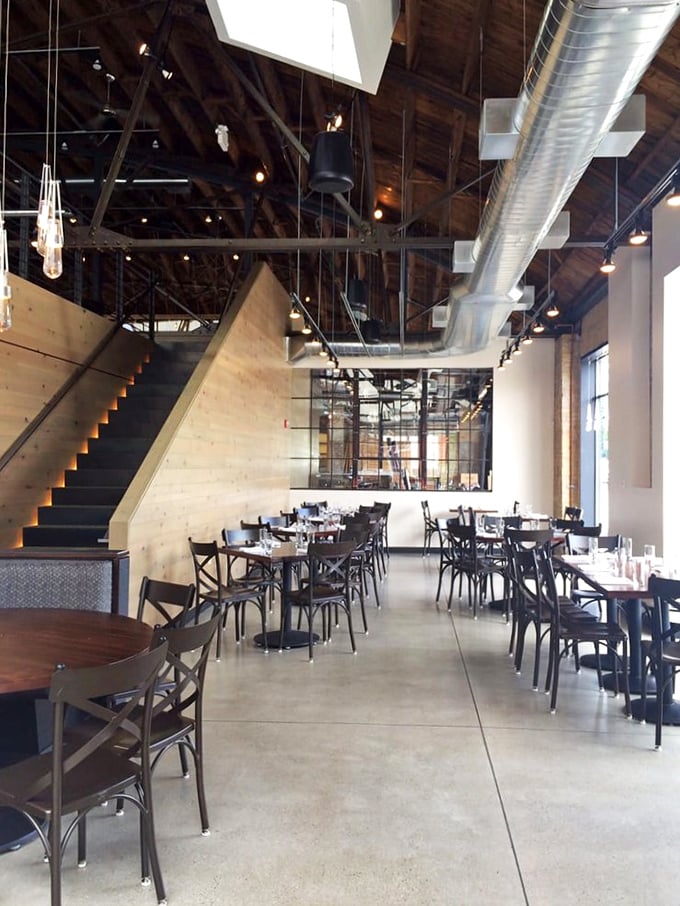 Soaring ceilings and exposed beams create a cathedral-like space for seafood worship. The staircase isn't just functional&mdash;it's architectural foreplay for your meal.
