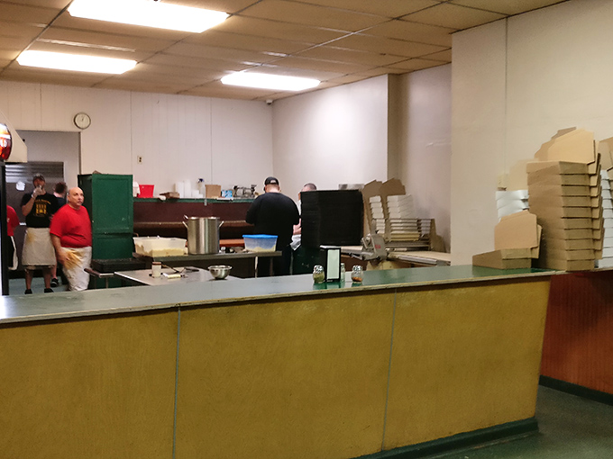 Behind the no-frills counter, pizza magic happens with practiced efficiency &ndash; no fancy showmanship, just decades of expertise on display.