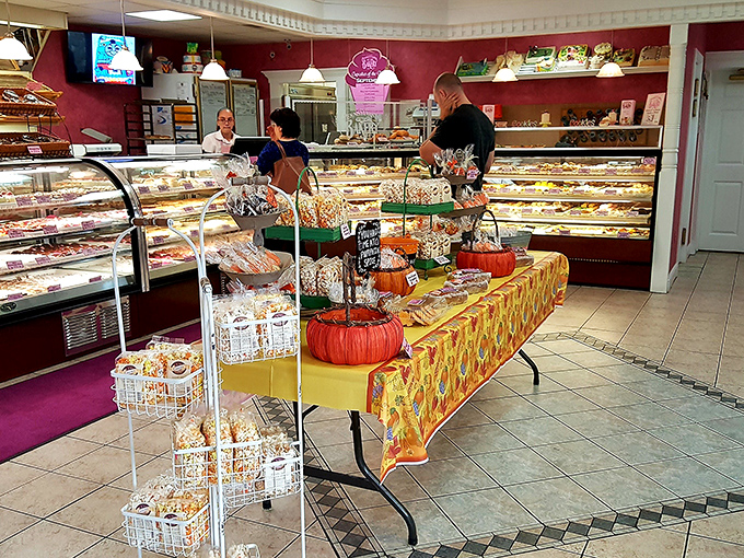 Burgundy walls frame a pastry paradise where diet plans come to die happy deaths and willpower dissolves faster than spun sugar.