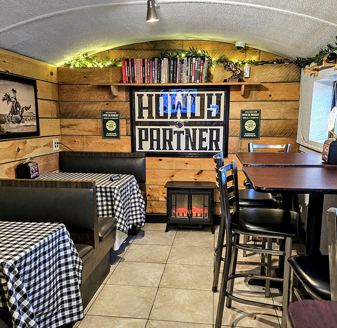 "HOWDY PARTNER" isn't just wall decor&mdash;it's the unofficial motto of this cozy wood-paneled sanctuary where checkered tablecloths signal delicious messiness ahead.