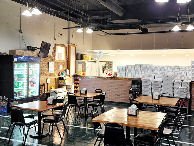 No-frills dining at its finest&mdash;wooden tables, simple chairs, and enough pizza boxes stacked to build a small fort. This is pizza preparation as performance art.