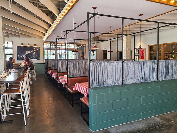 Classic red-checkered tablecloths meet modern industrial design, creating that perfect "I've just discovered the coolest spot in town" atmosphere.
