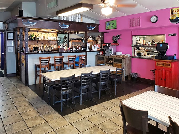 The vibrant pink walls and well-stocked bar create an atmosphere that's part fiesta, part serious seafood business.