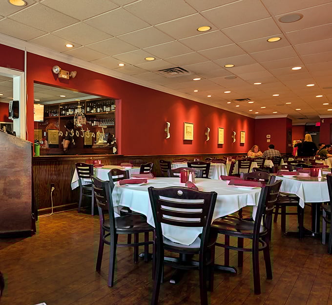 Rich red walls and crisp white tablecloths create the kind of ambiance that makes every meal feel like a celebration.