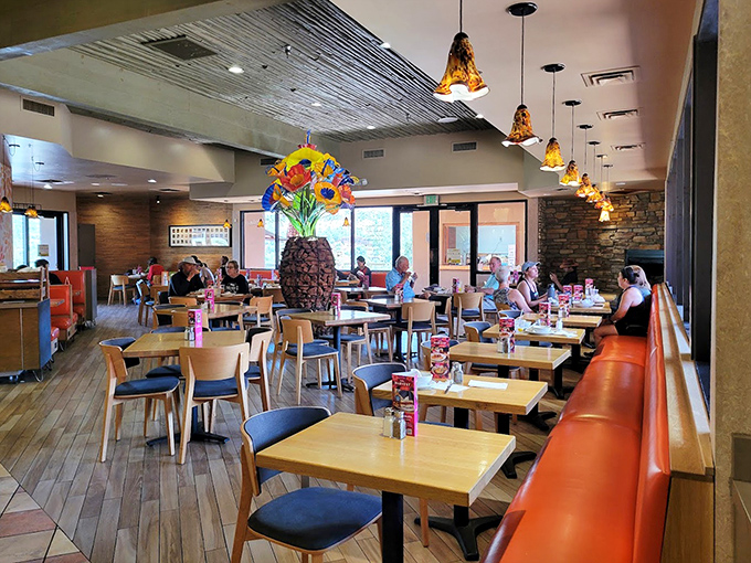 A welcoming interior where amber pendant lights cast a warm glow over wooden tables &ndash; comfort before you even taste the food.