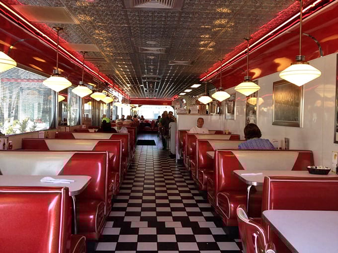 Step inside to a checkerboard floor paradise where cherry-red vinyl booths and a pressed tin ceiling create the quintessential American diner experience.